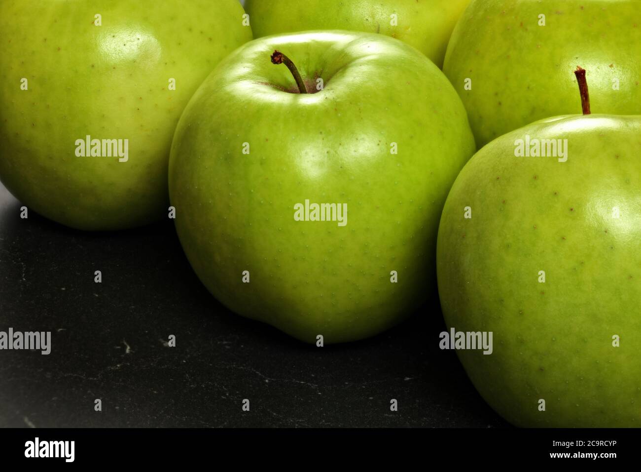 Closeup of green apples on black board Stock Photo - Alamy