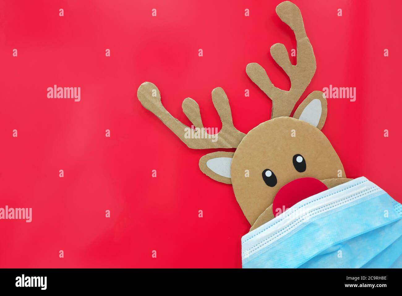 Cardboard cutout of cute reindeer peeking while wearing a face mask ...