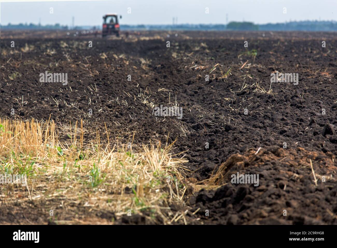 farm agriculture harrowing, the tractor cultivation of the field after ...