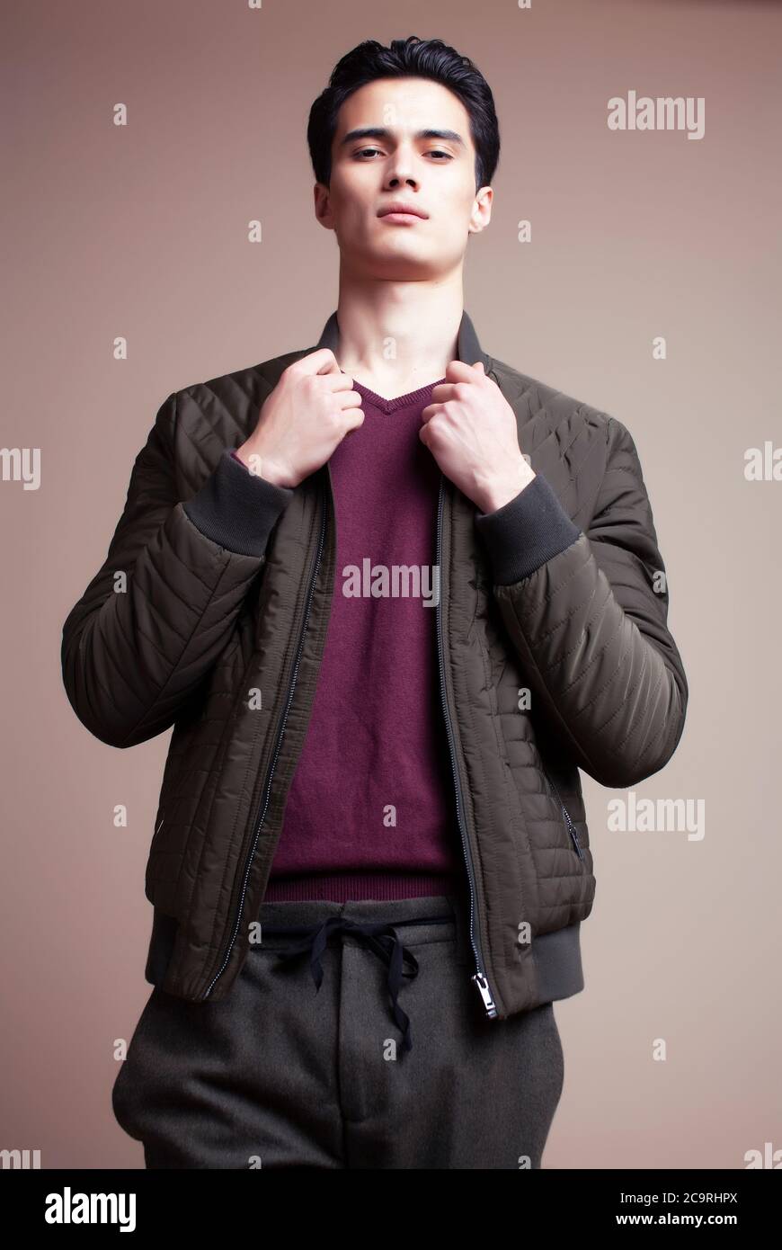 young pretty asian man posing in fashion style on light brown ...