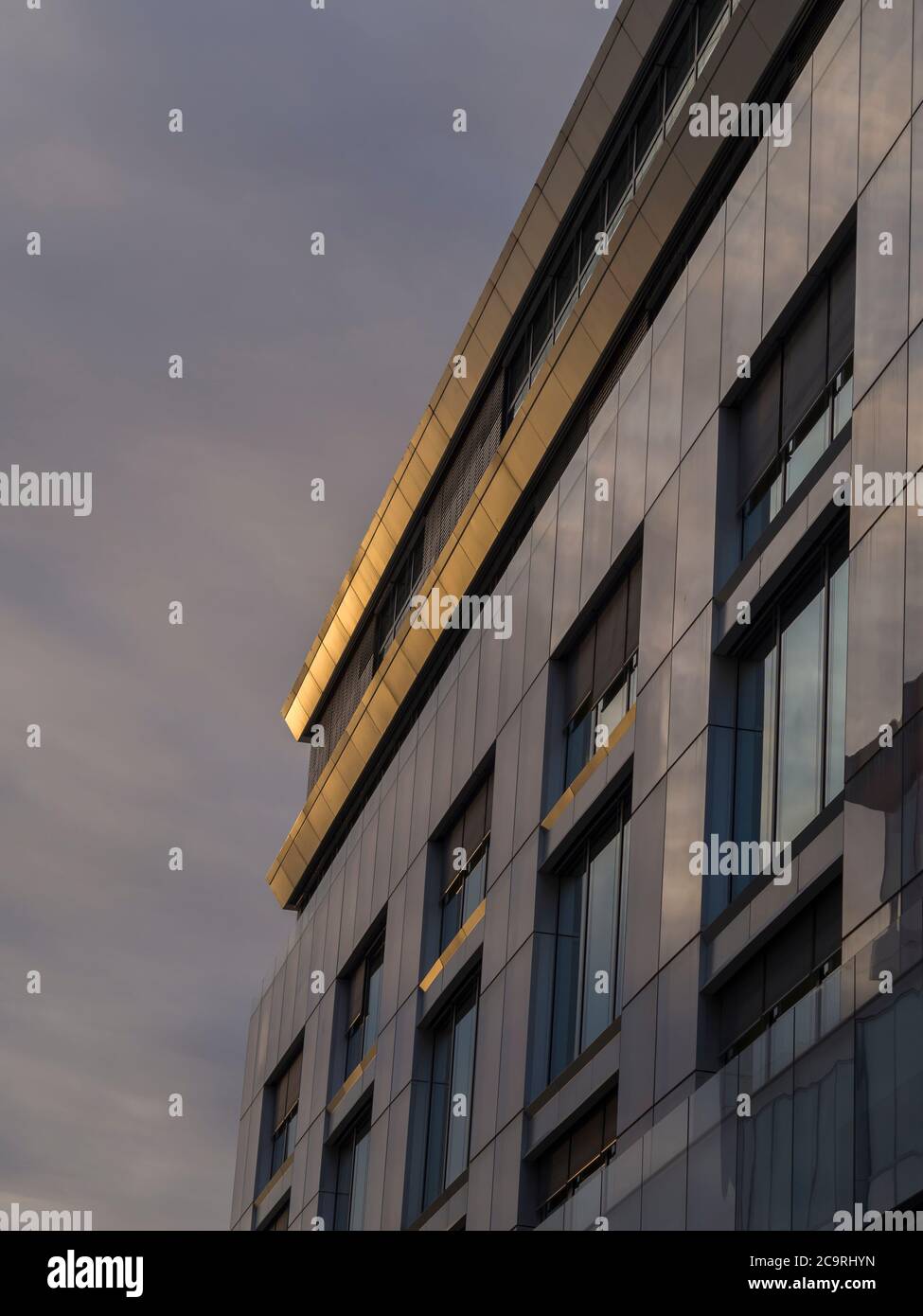 detail of gray office building with big windows in golden evening light ...