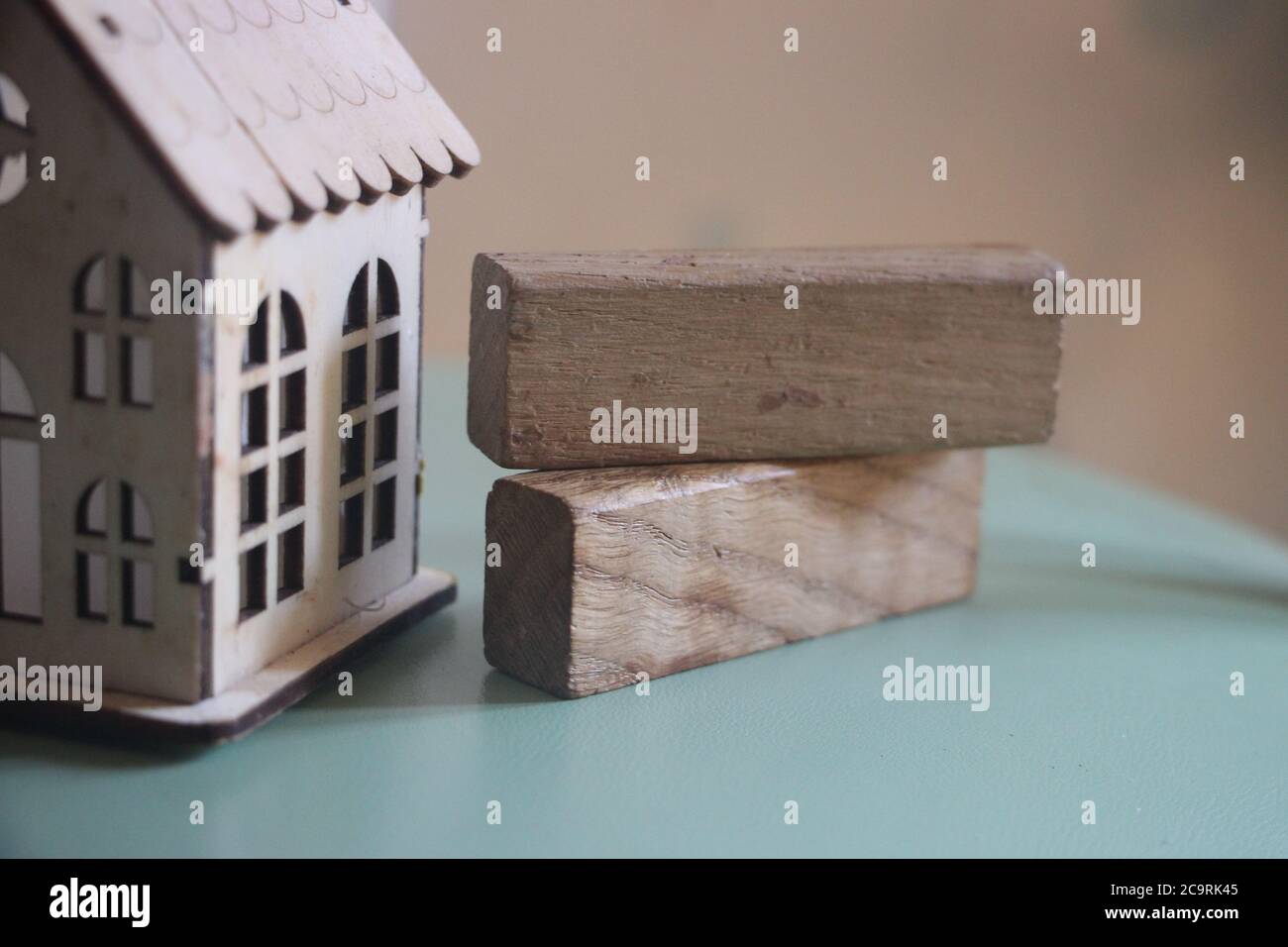 Miniature wooden toy house and two wooden building blocks. Real estate ...