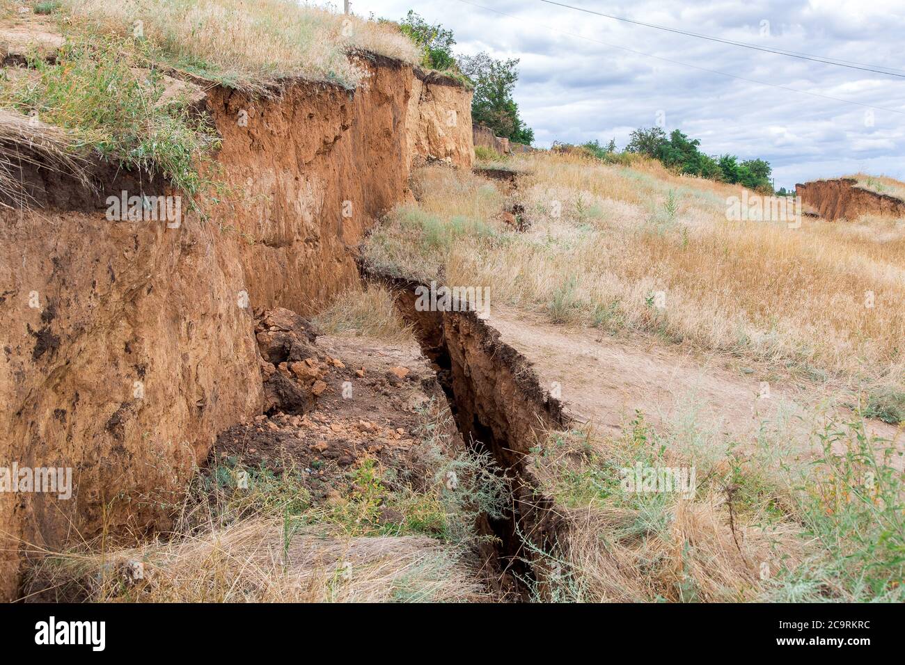 landslide with cracks in the ground, the earth sank down Stock Photo ...