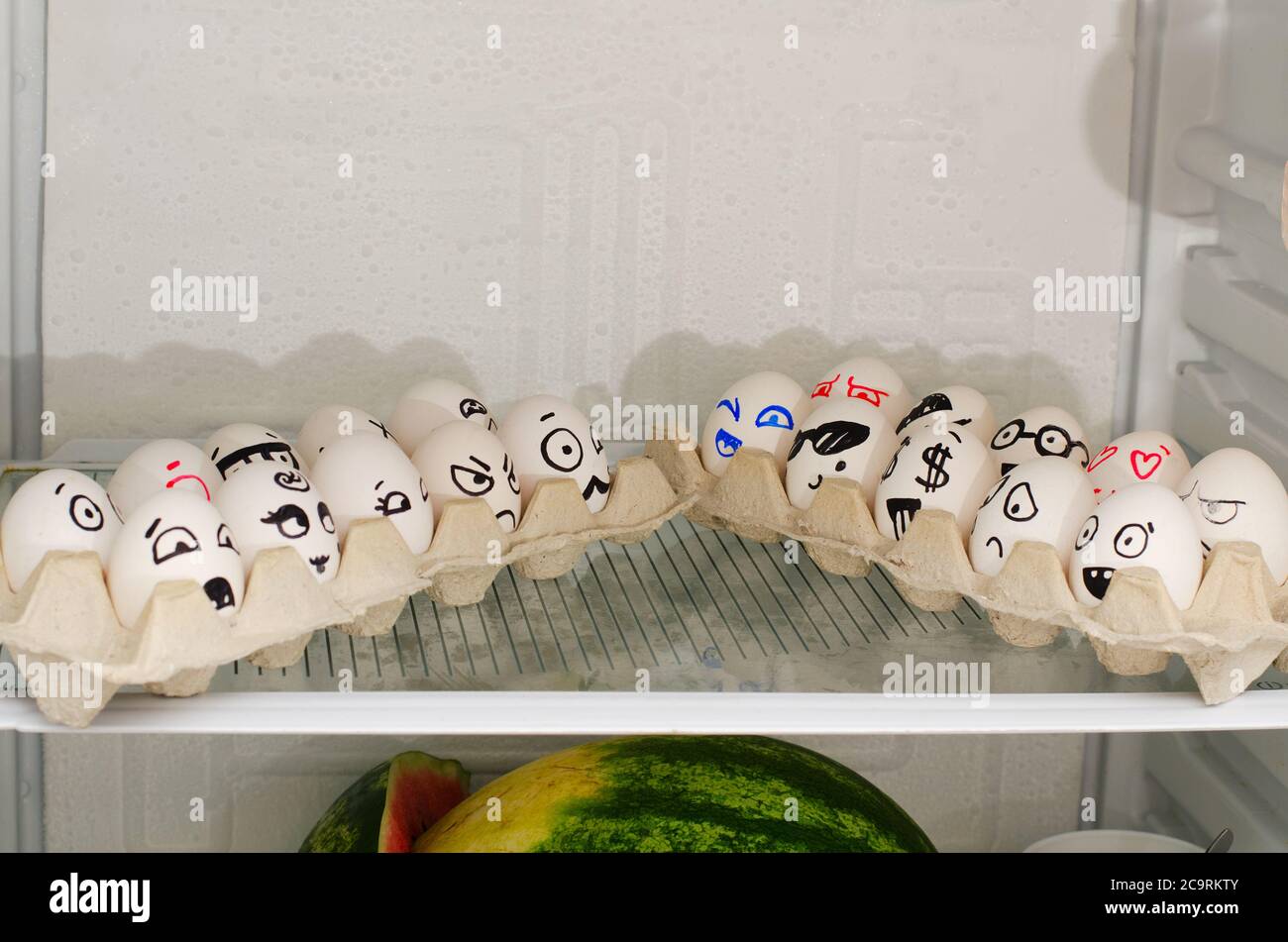 Two trays of eggs with smiles facing each other on a shelf in the ...
