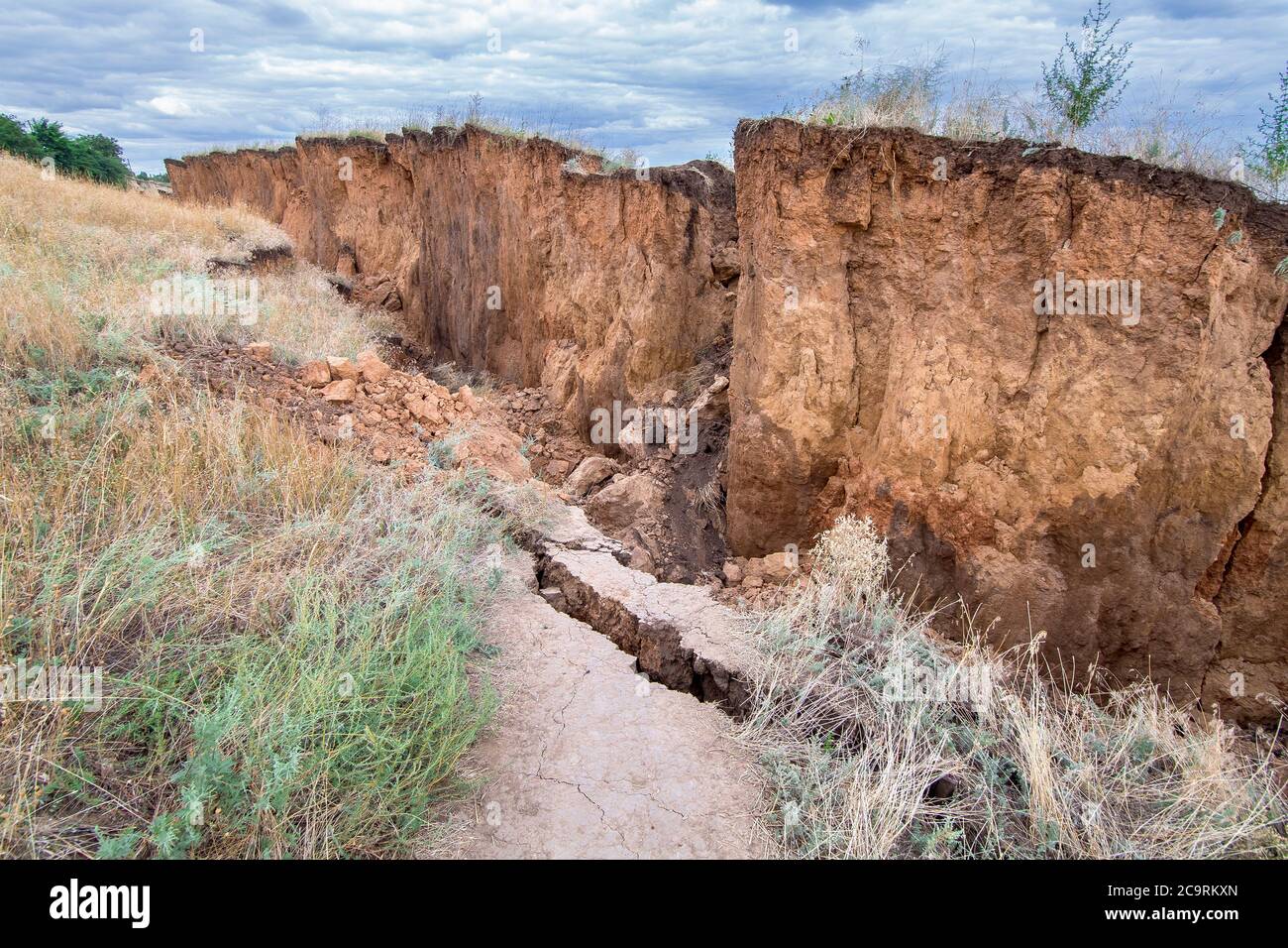 layers of earth with cracks on trail path due to landslides of the soil ...