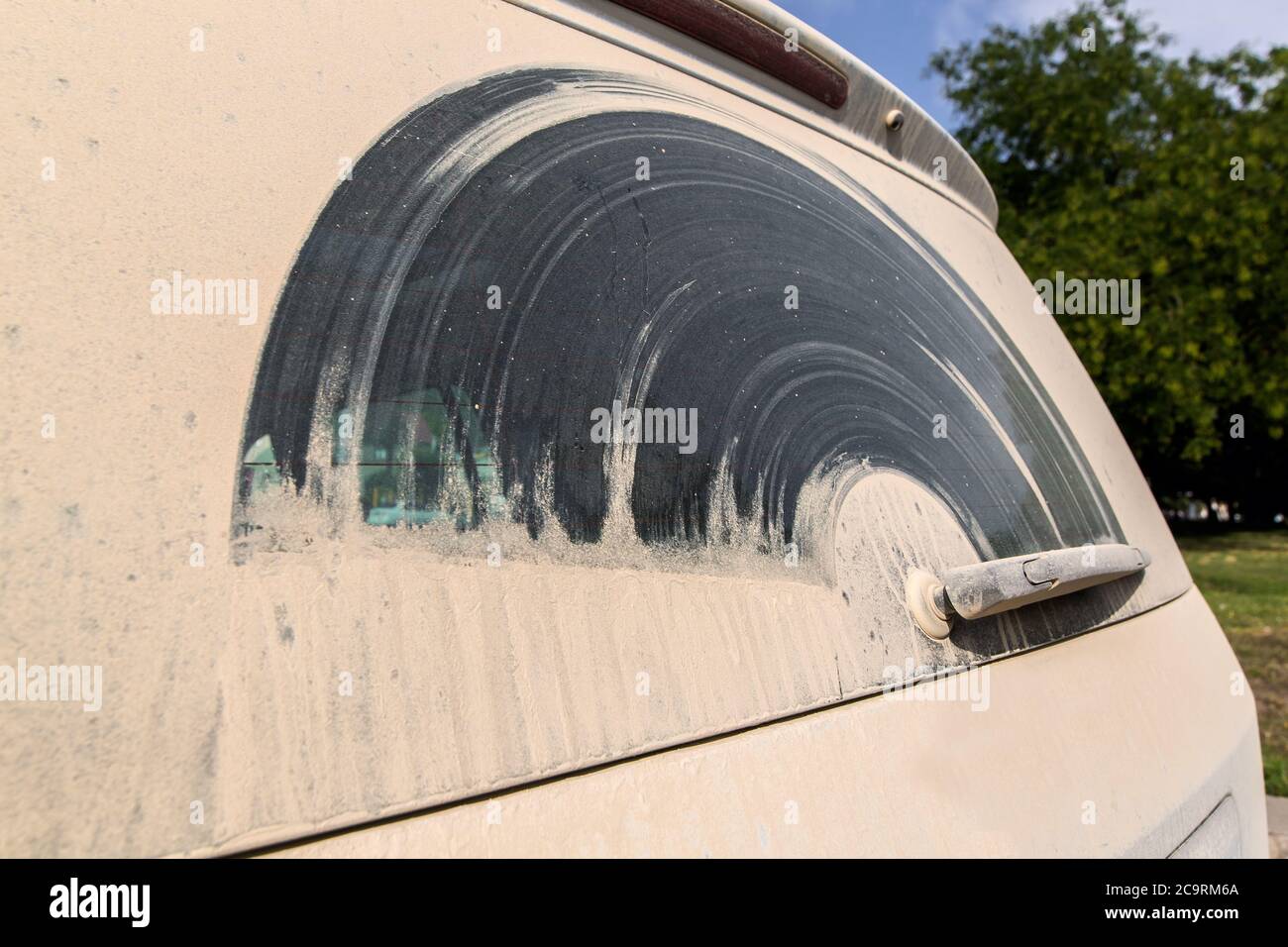 Dirty car in dust view of windscreen of a back view behind at the left ...