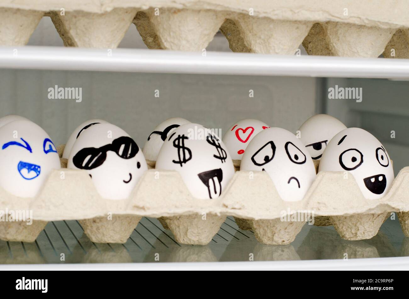 Eggs with painted emotions in a tray on a shelf in the refrigerator ...