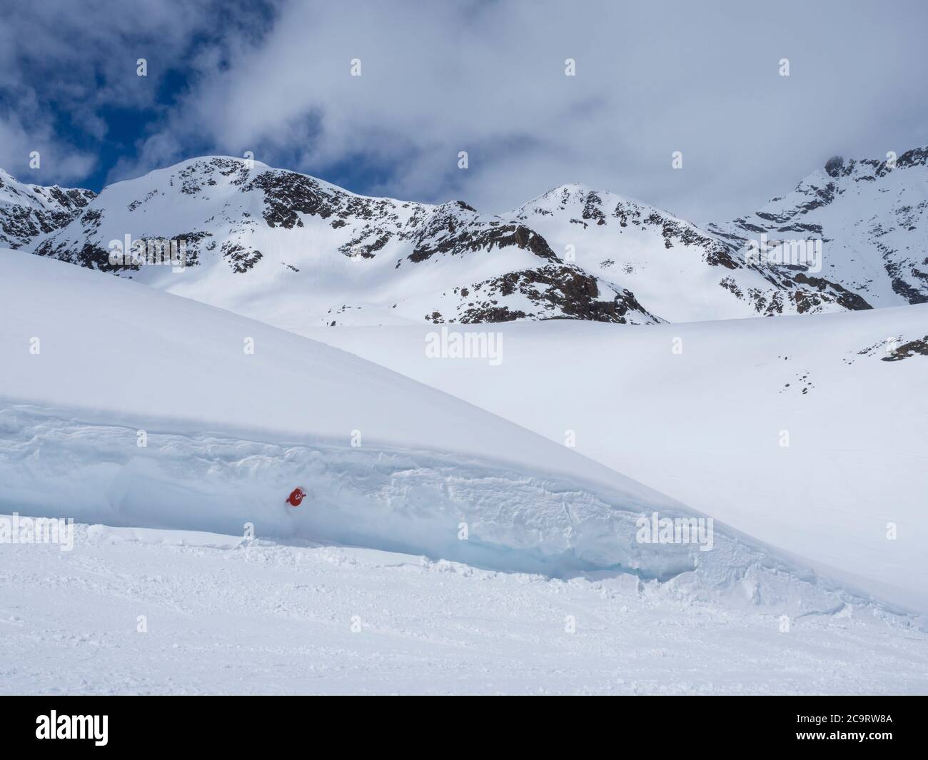Winter landscape with empty red piste sign, snow covered mountain ...