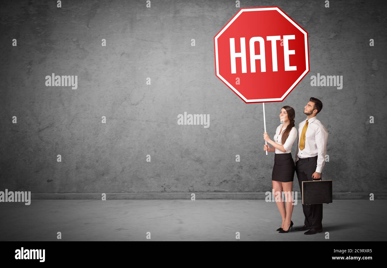 Young business person holding road sign with HATE inscription, new ...