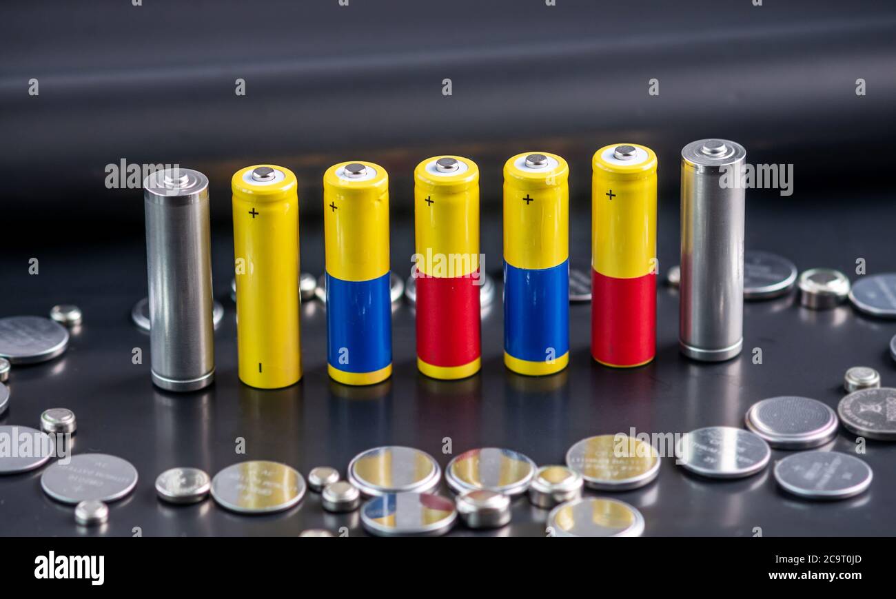 Used batteries stand flat and scattered on the table. Concept of eco ...
