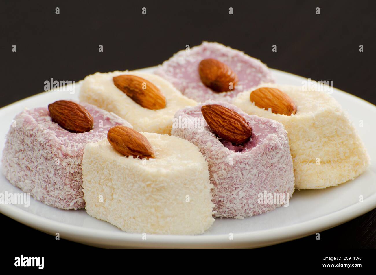 Turkish Delight with almonds on a saucer, close-up, black background ...