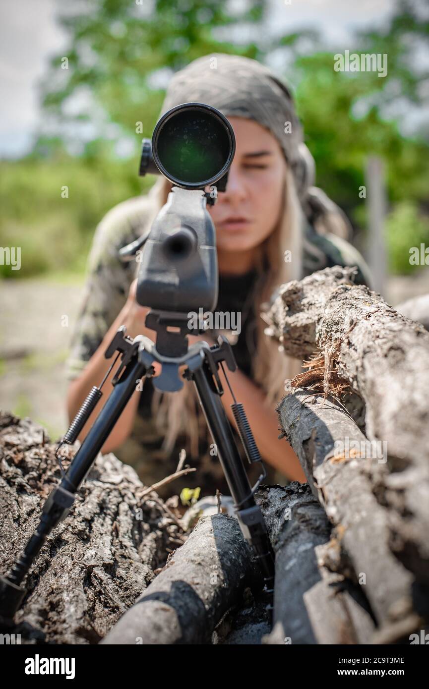 Female soldier shooting with sniper rifle. Woman with weapon. Firearm ...