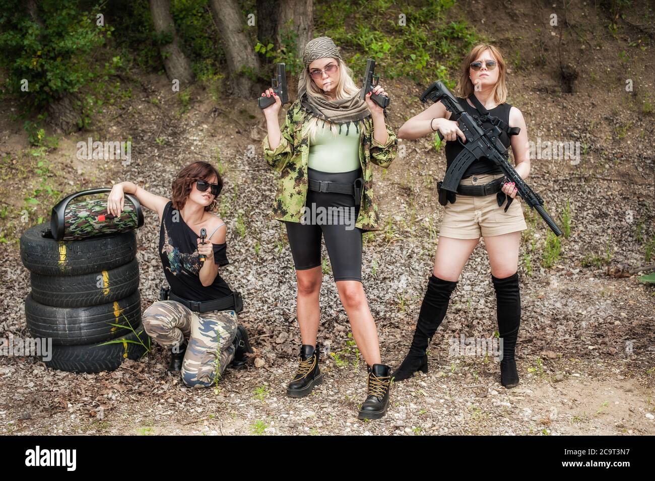 Group of three beautiful and attractive female soldier with guns and ...