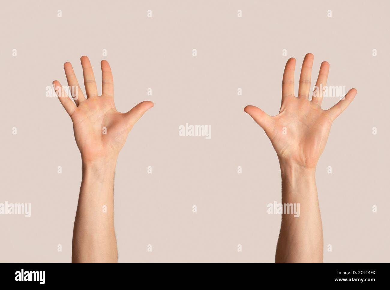 Millennial man raising both hands up on light background, closeup Stock ...