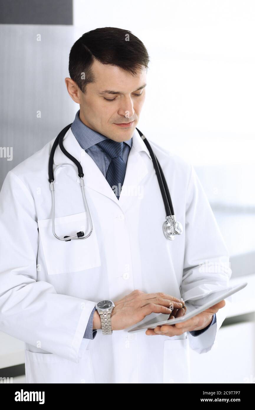 Doctor man using tablet computer for network research or virtual ...