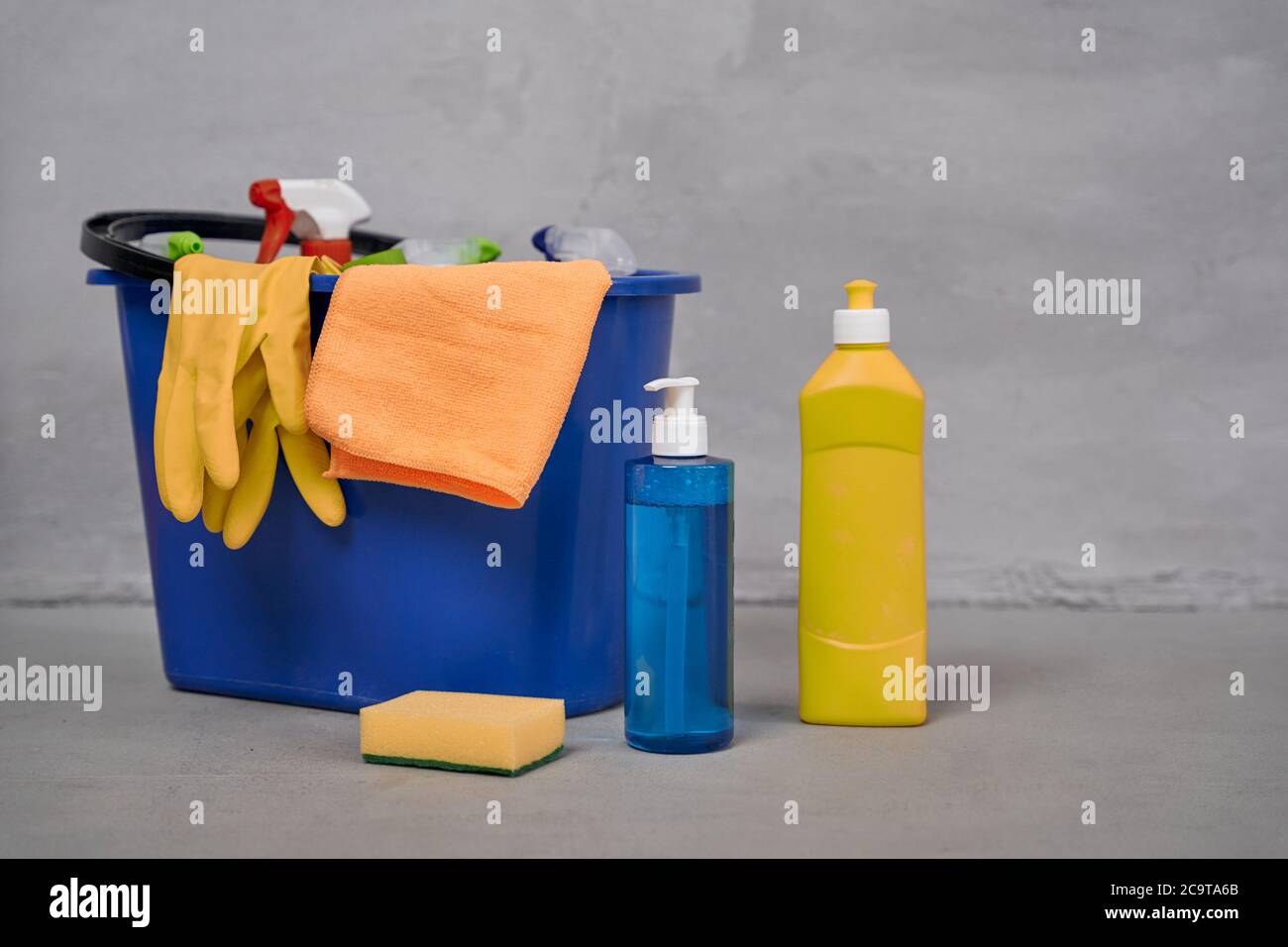 Close up shot of plastic bucket with cleaning supplies and bottles with ...