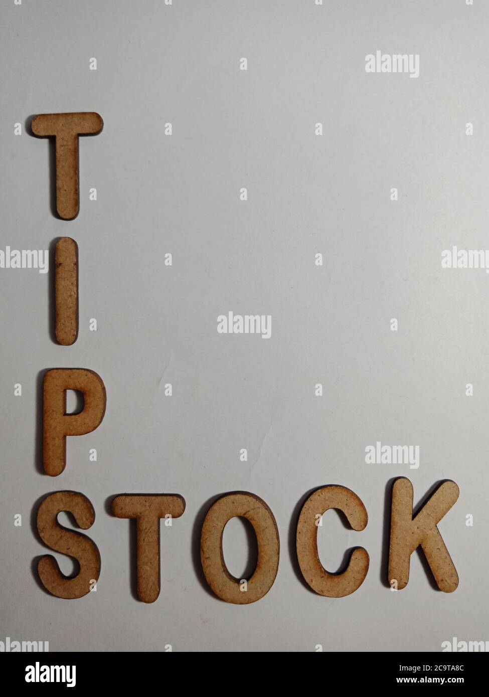 Stock tips word presented on white surface with wooden cross text cloud ...