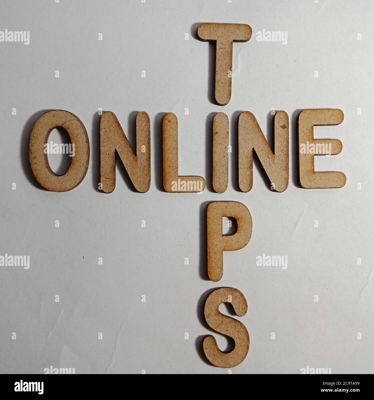 Online tips word presented on white surface with wooden cross text ...