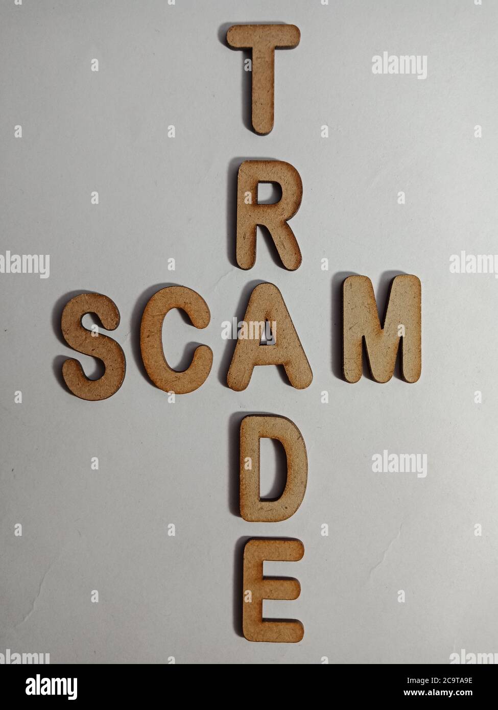 Trade scam word presented on white surface with wooden cross text cloud ...