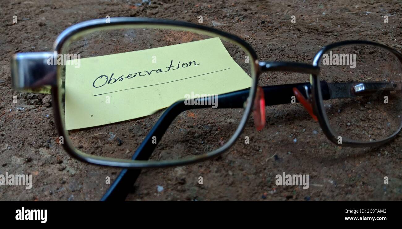Observation word displaying on paper slip behind the specs glass with ...