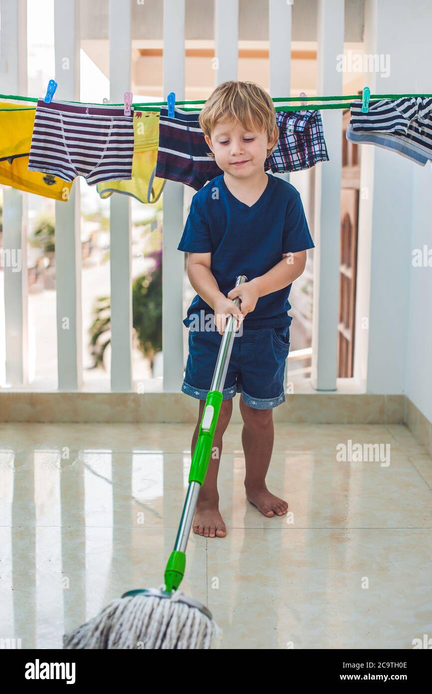 kid boy cleaning room, washing floor with mop. Little home helper Stock ...