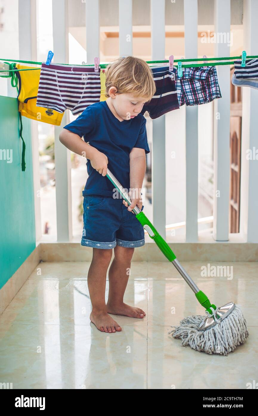 kid boy cleaning room, washing floor with mop. Little home helper Stock ...