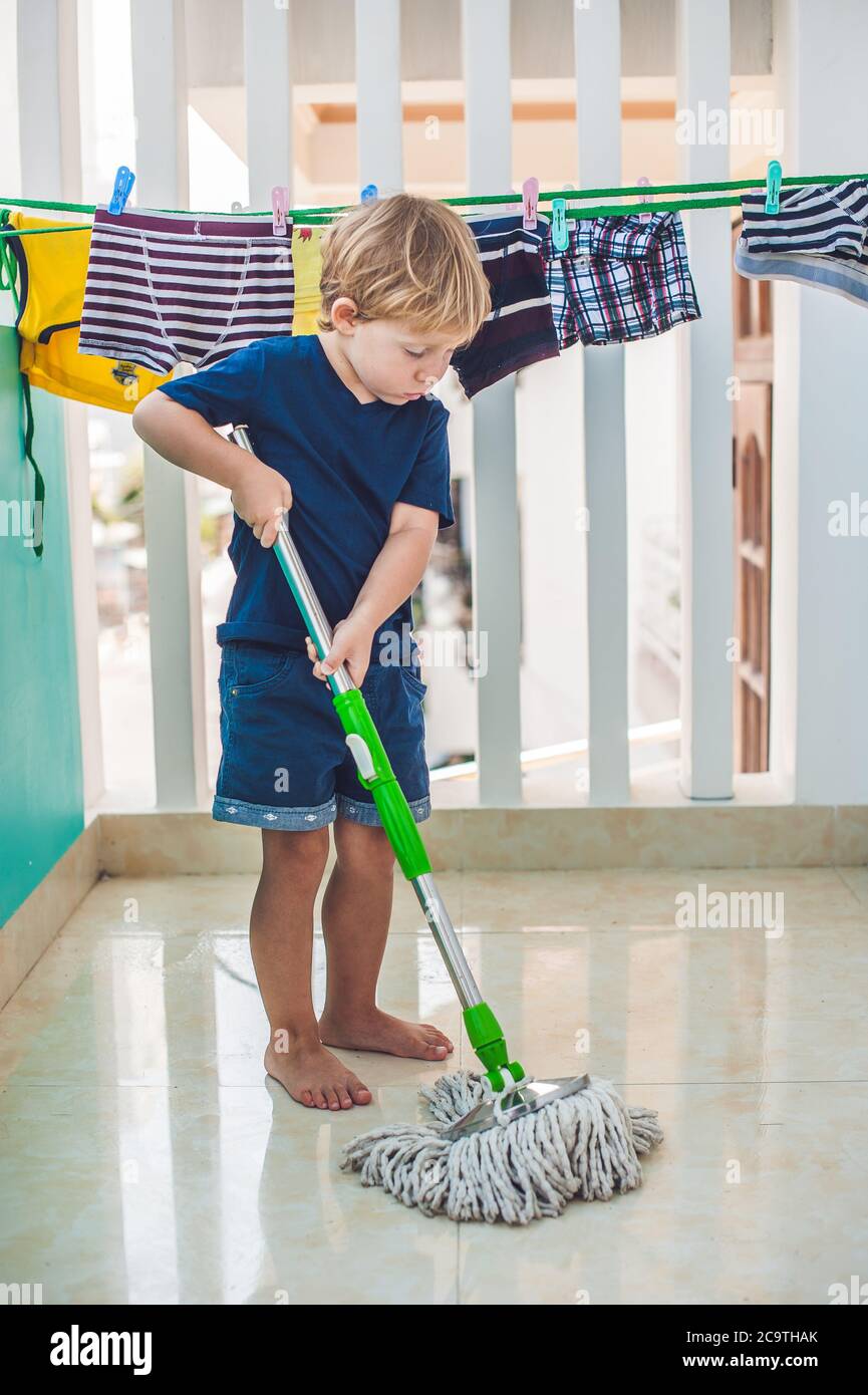 kid boy cleaning room, washing floor with mop. Little home helper Stock ...