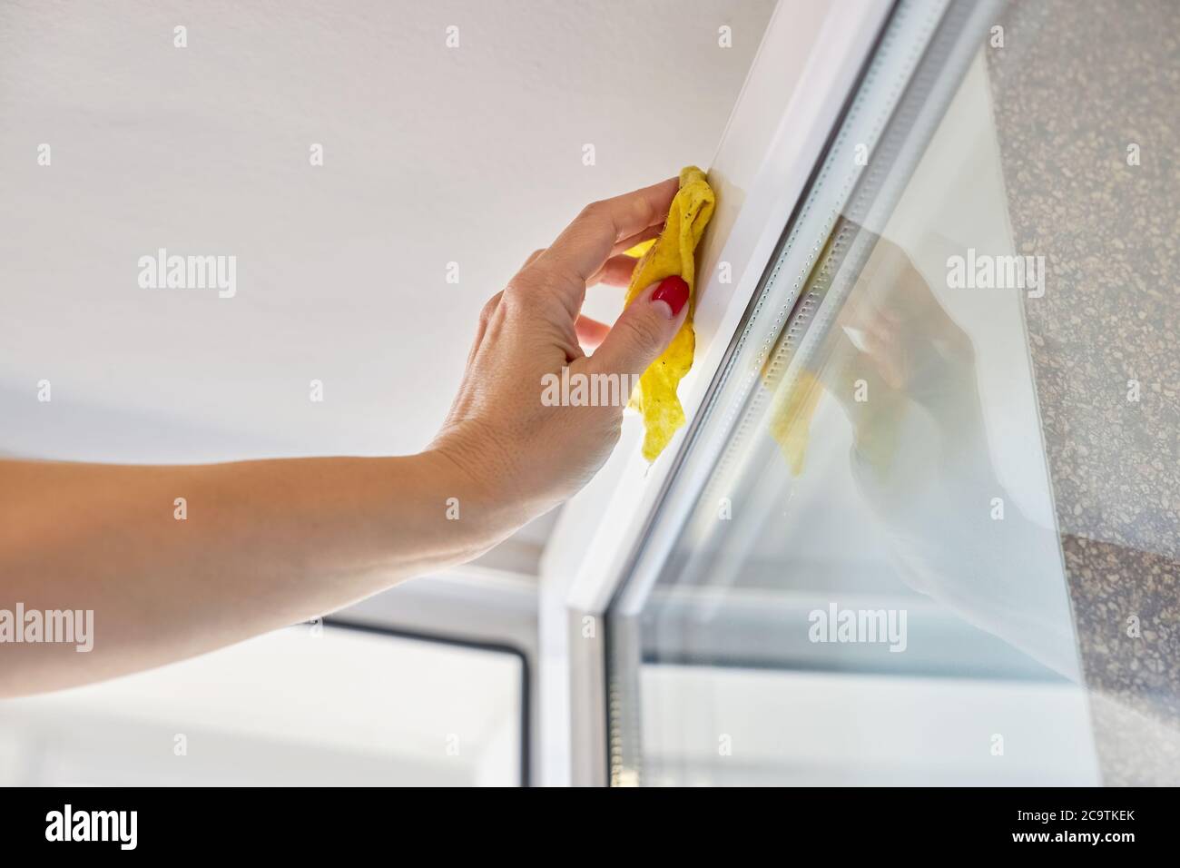 Woman washes the frame of open window with yellow rag Stock Photo - Alamy