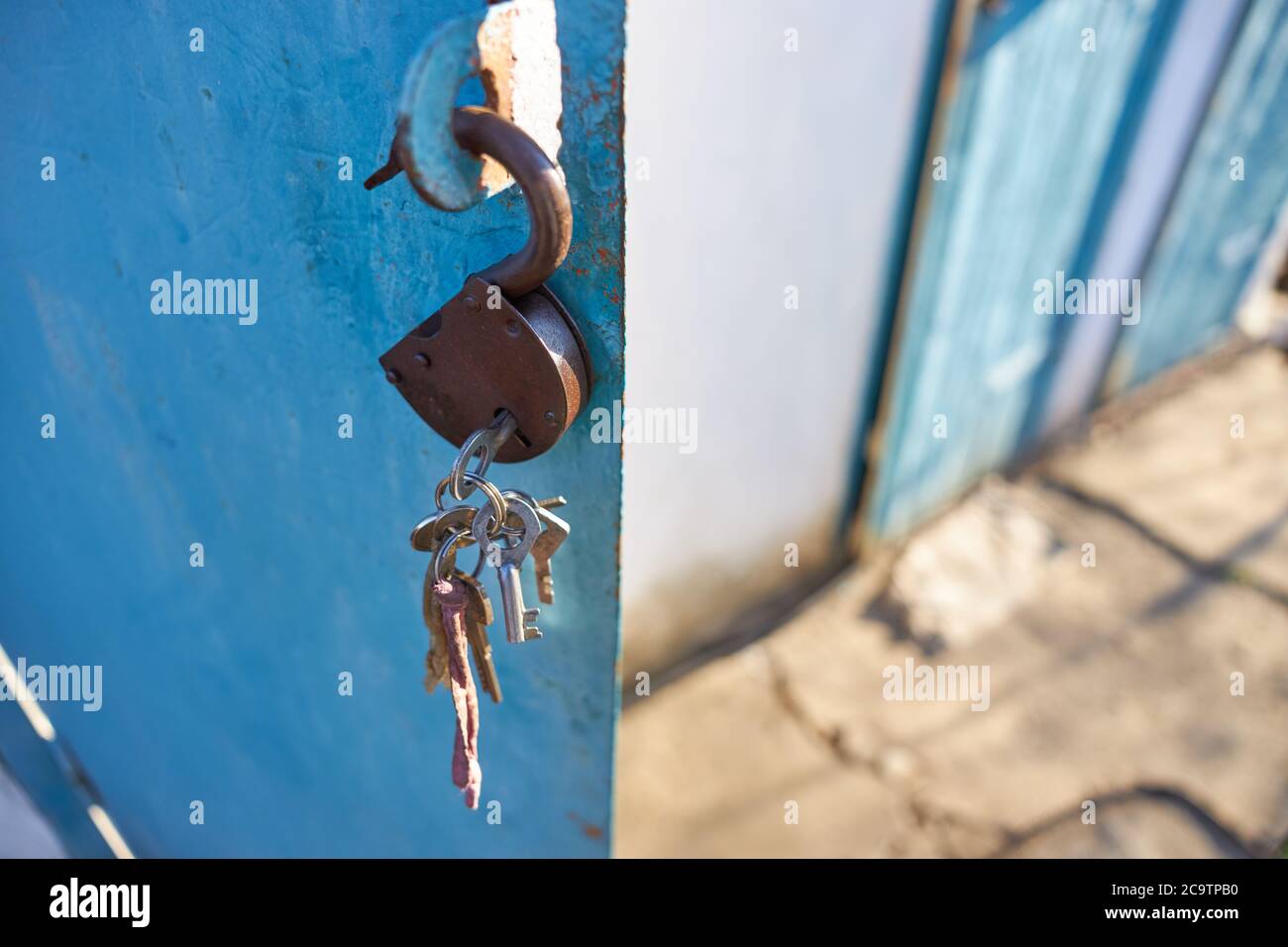 A lock with a bunch of keys hanging in an open metal door Stock Photo ...