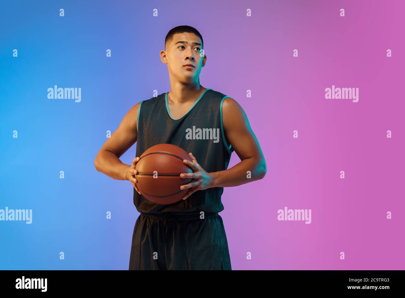 Handsome. Young basketball player confident posing with ball on ...