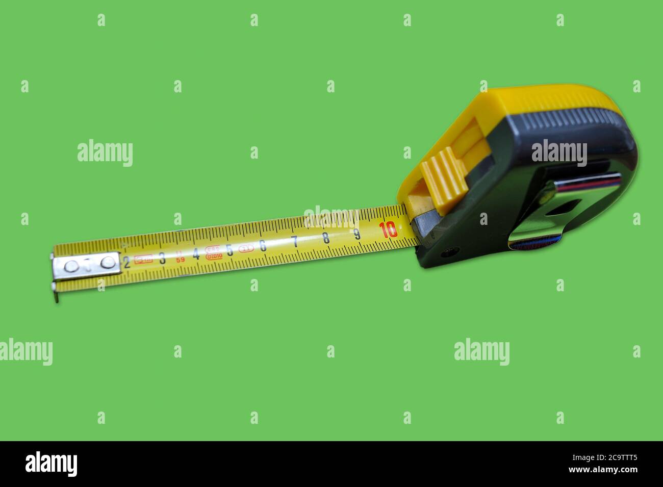 Extended tape measure on green background Stock Photo - Alamy