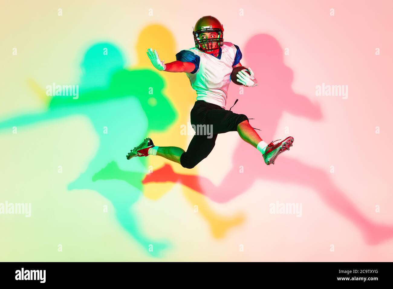 American football player isolated on gradient studio background in neon ...
