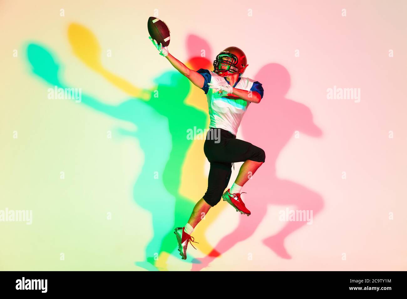 American football player isolated on gradient studio background in neon ...