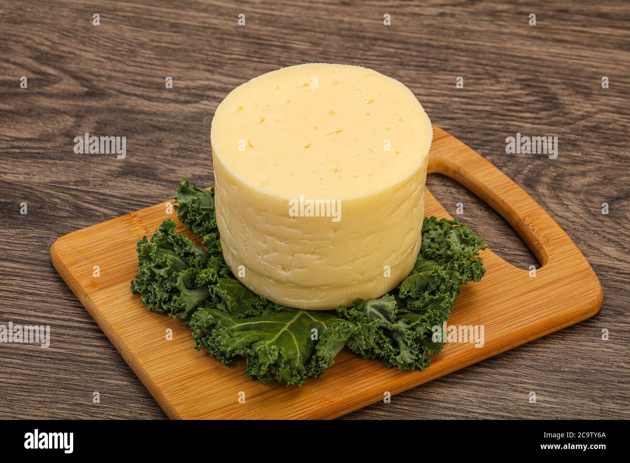 Yellow round dairy soft cheese piece Stock Photo - Alamy