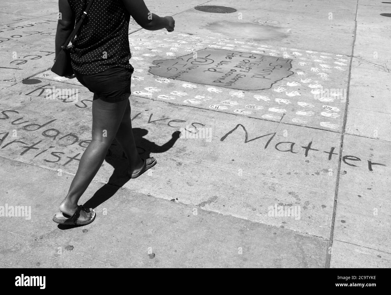 Woman legs stepping on sidewalk spray sign Stock Photo - Alamy
