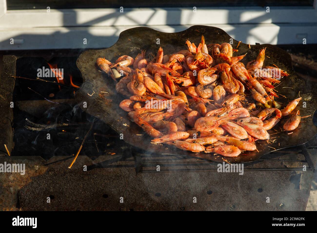 shrimp. Shrimps are cooked in a pan over a fire. Bonfire seafood Stock ...