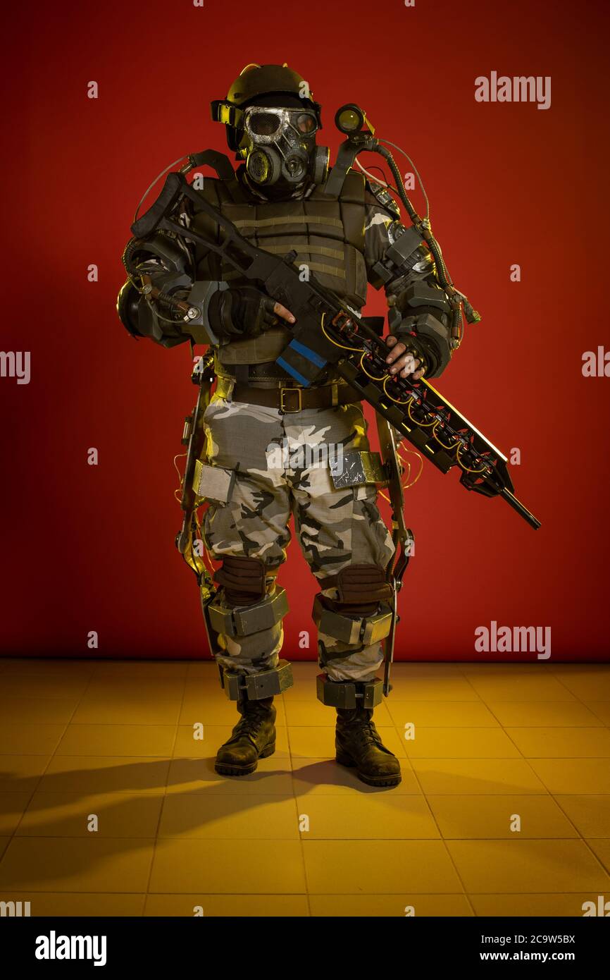 Actor man in a military helmet, mask and uniform with a gauss rifle in ...