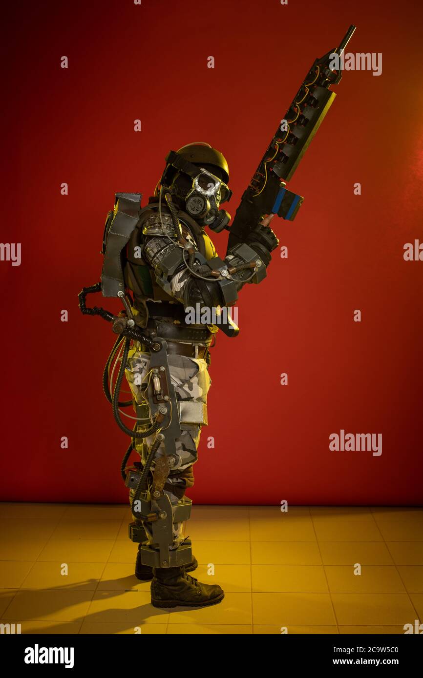 Actor man in a military helmet, mask and uniform with a gauss rifle in ...