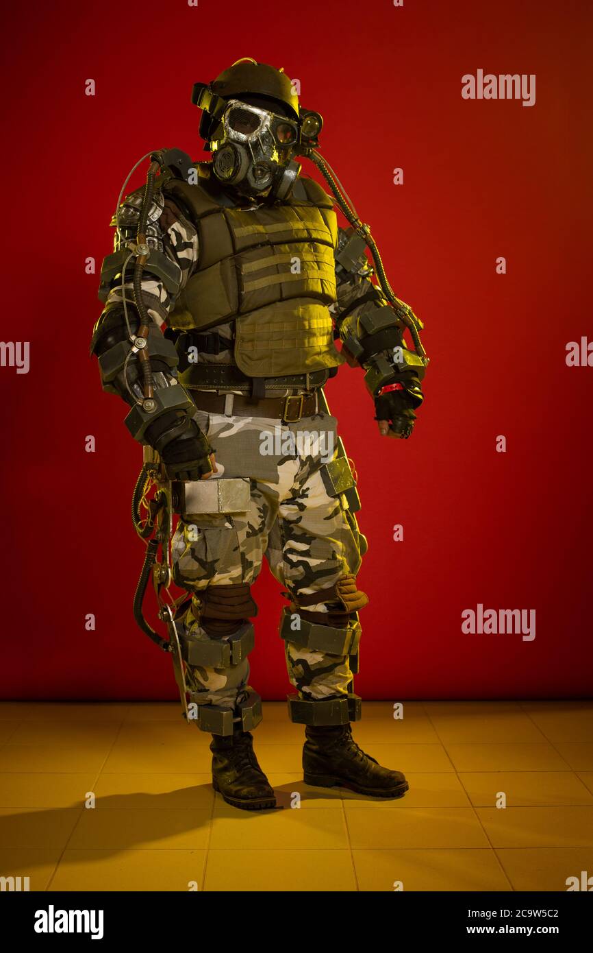 Actor man in a military helmet, mask and uniform with a gauss rifle in ...