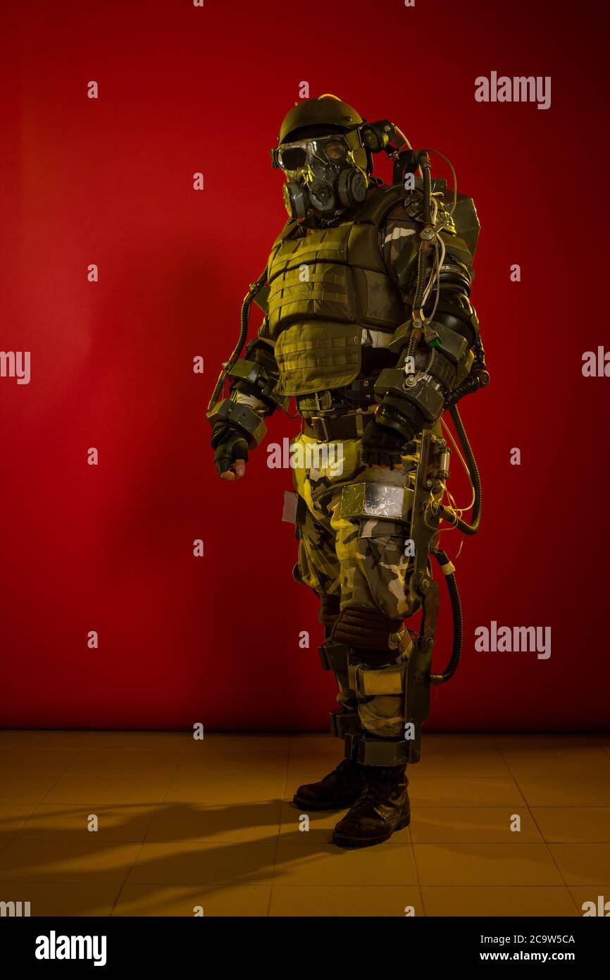 Actor man in a military helmet, mask and uniform with a gauss rifle in ...