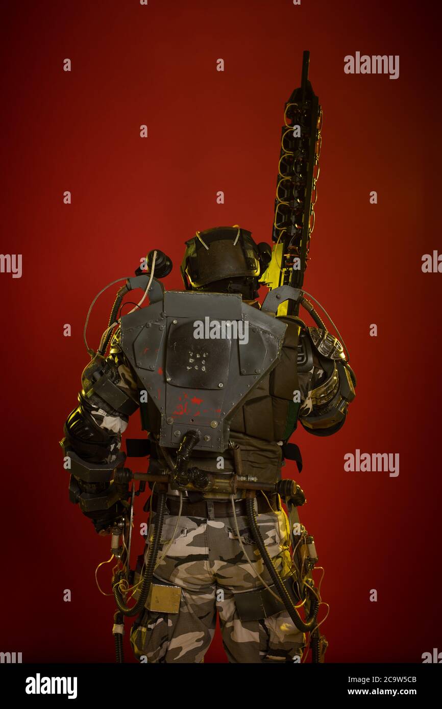 Actor man in a military helmet, mask and uniform with a gauss rifle in ...