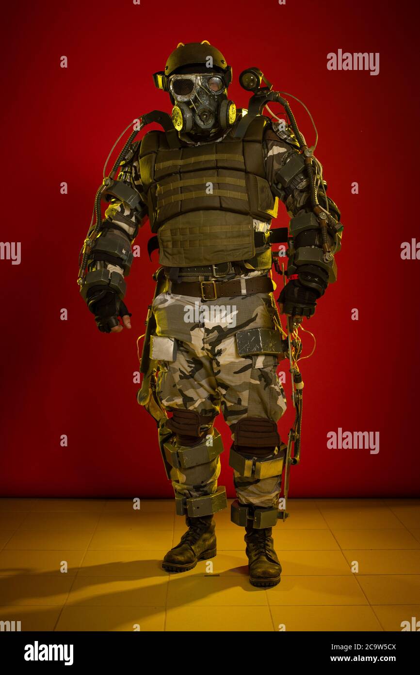 Actor man in a military helmet, mask and uniform with a gauss rifle in ...