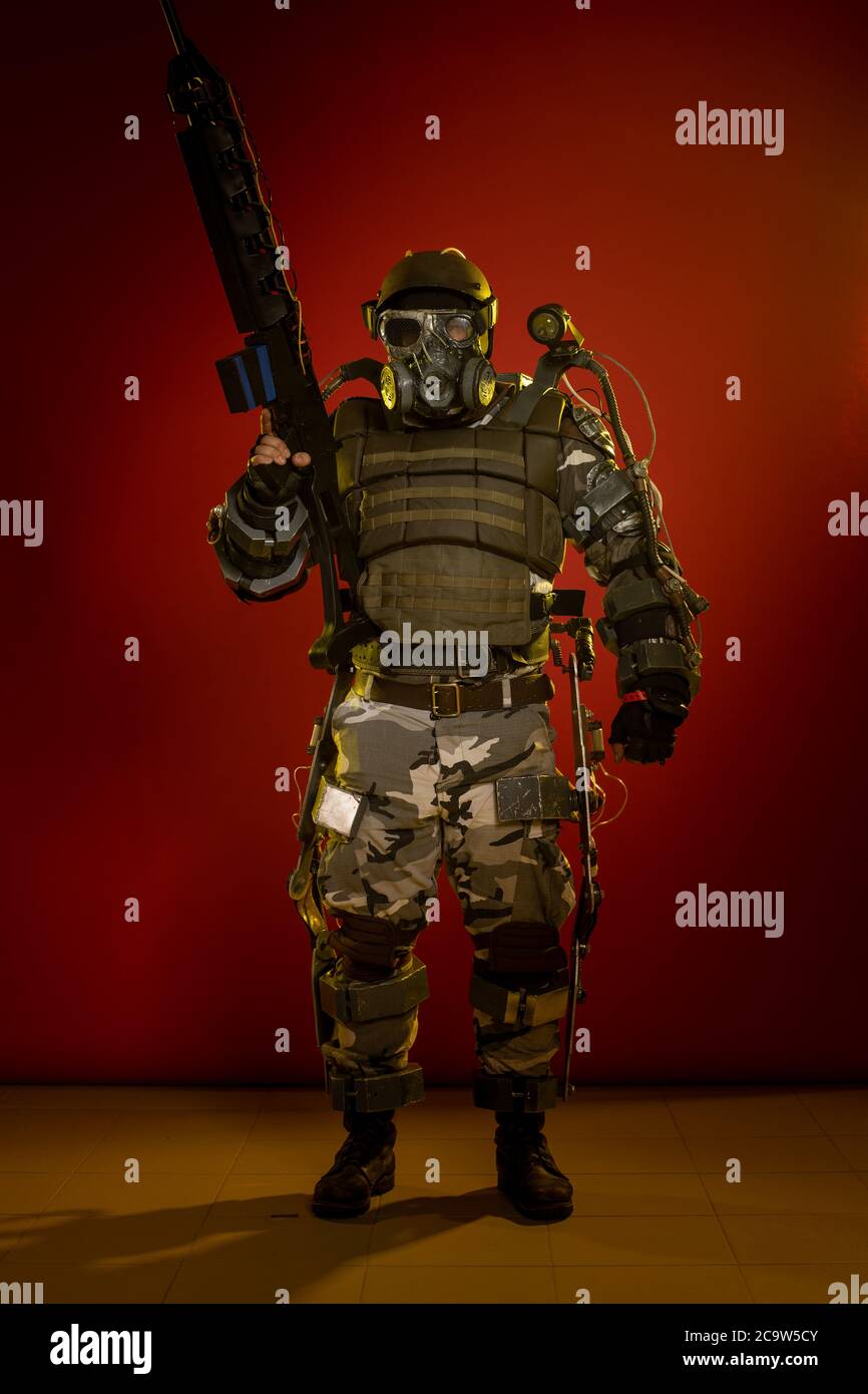 Actor man in a military helmet, mask and uniform with a gauss rifle in ...