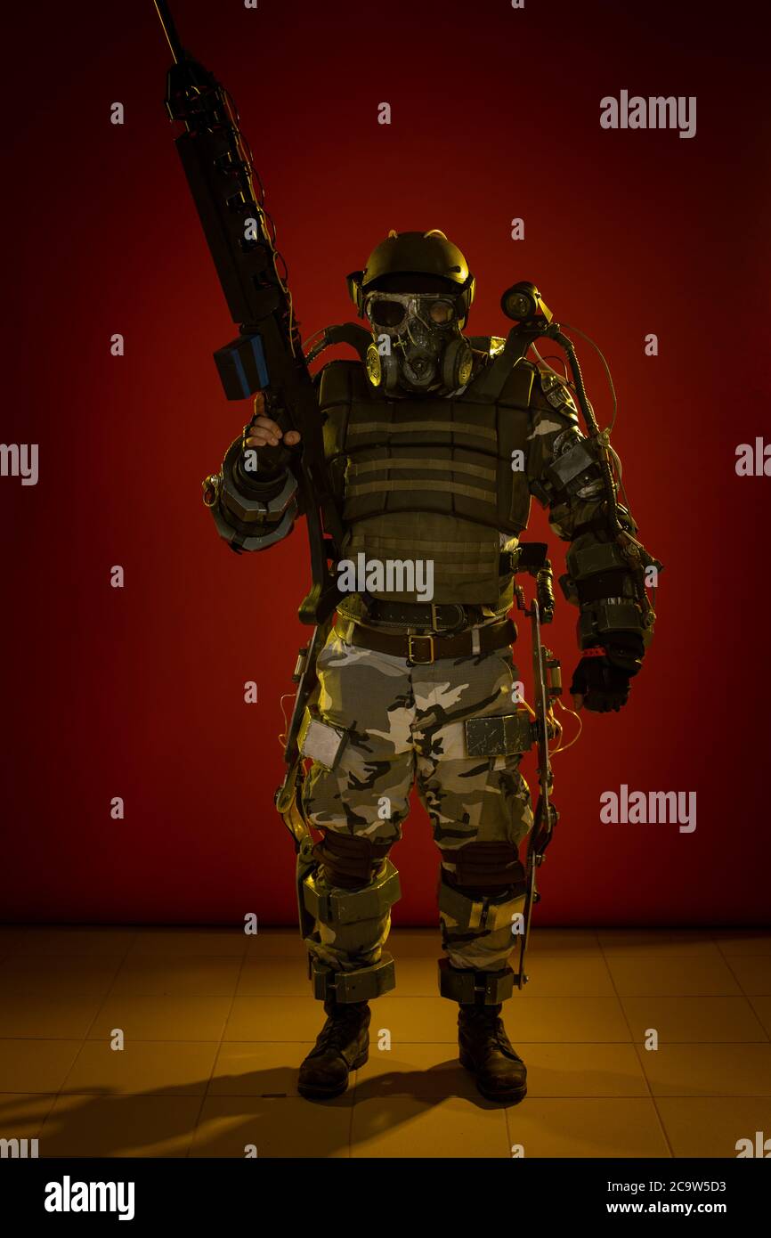 Actor man in a military helmet, mask and uniform with a gauss rifle in ...
