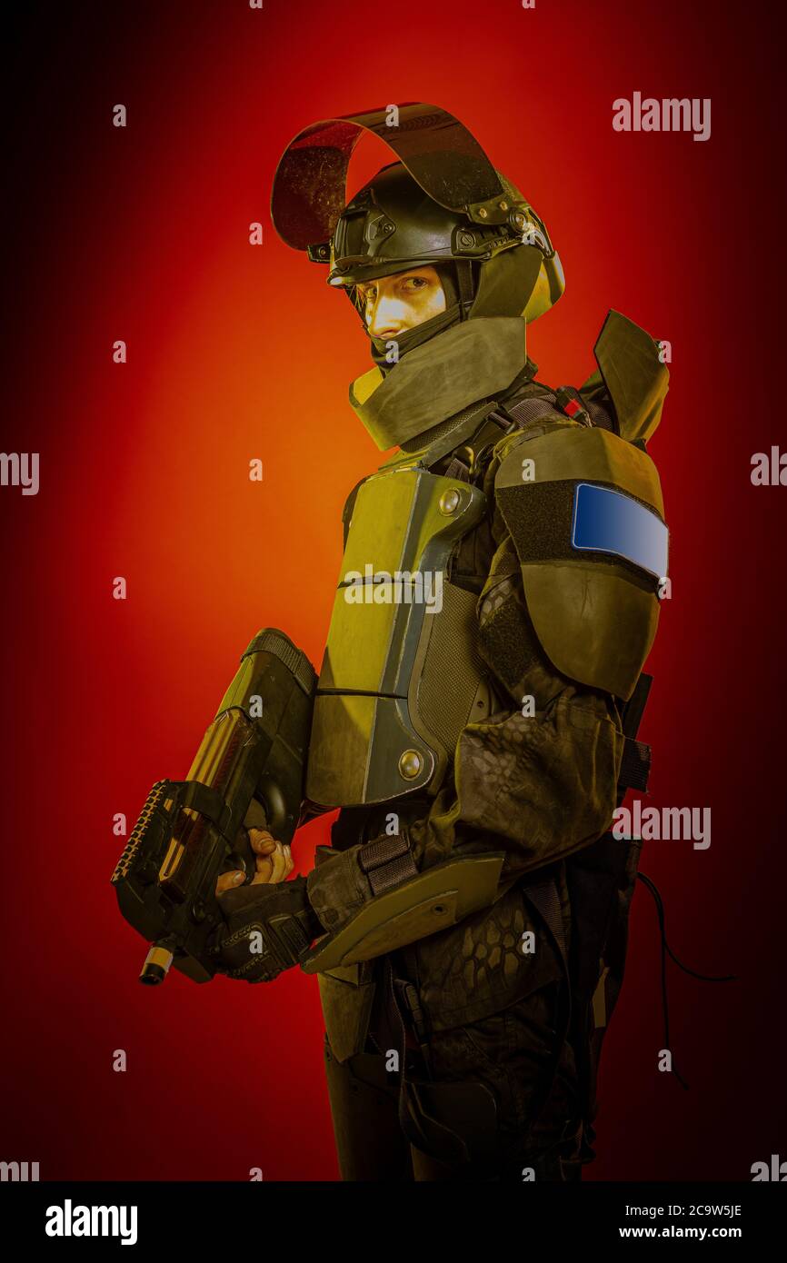 Actor man in a military helmet, mask and uniform with a gauss rifle in ...