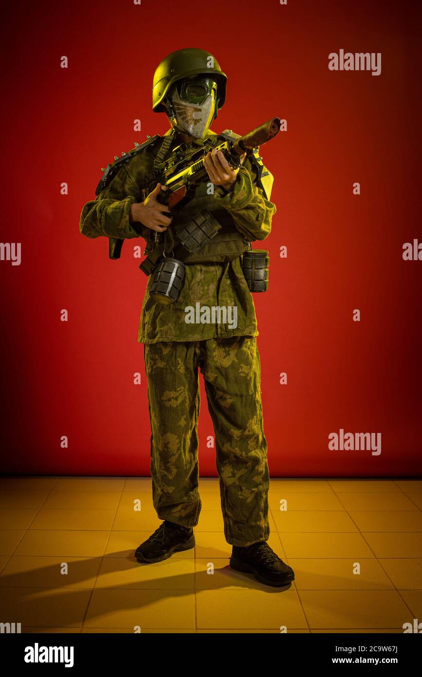 Actor man in a military helmet, mask and uniform posing on a red ...
