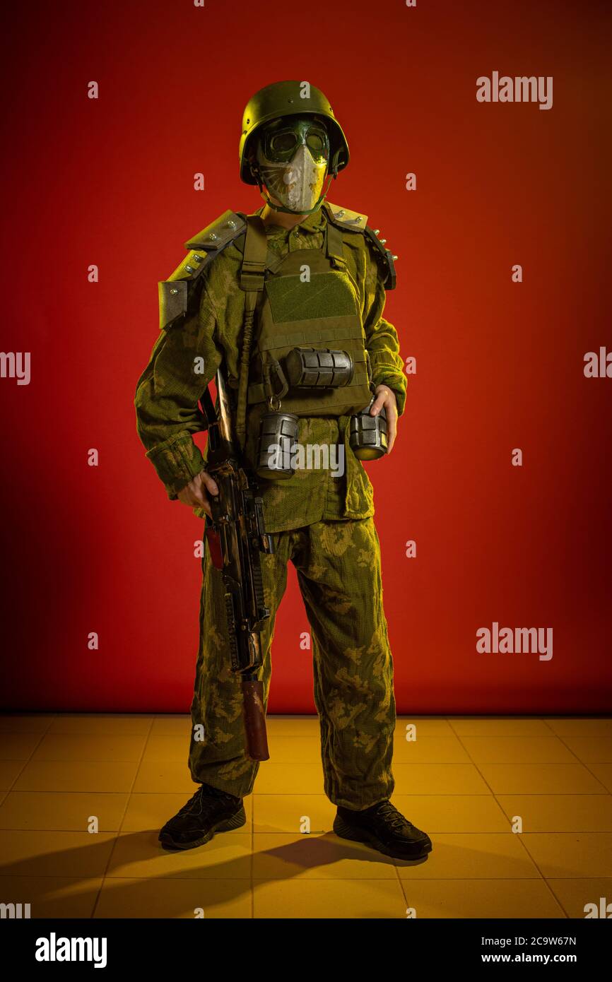 Actor man in a military helmet, mask and uniform posing on a red ...