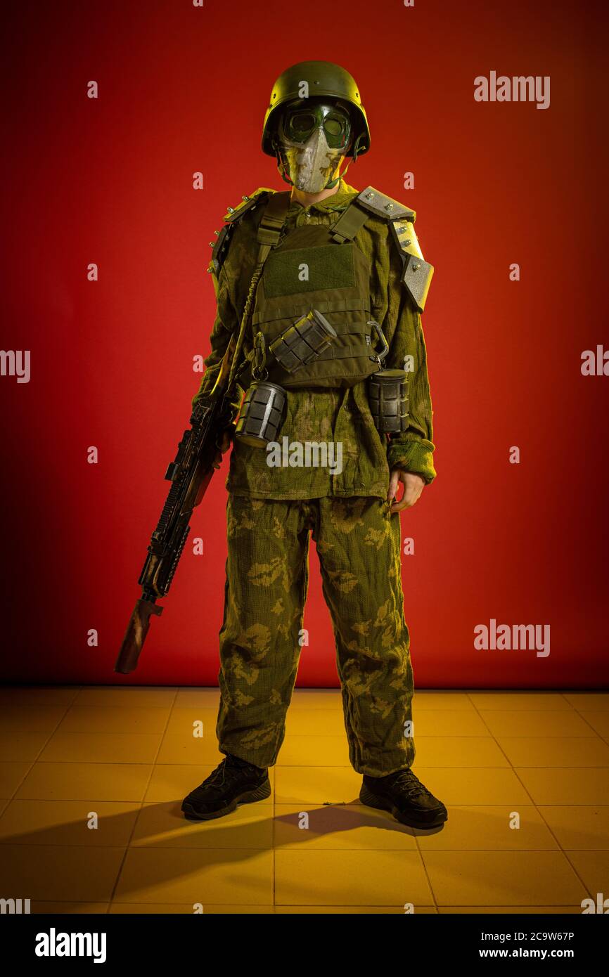 Actor man in a military helmet, mask and uniform posing on a red ...