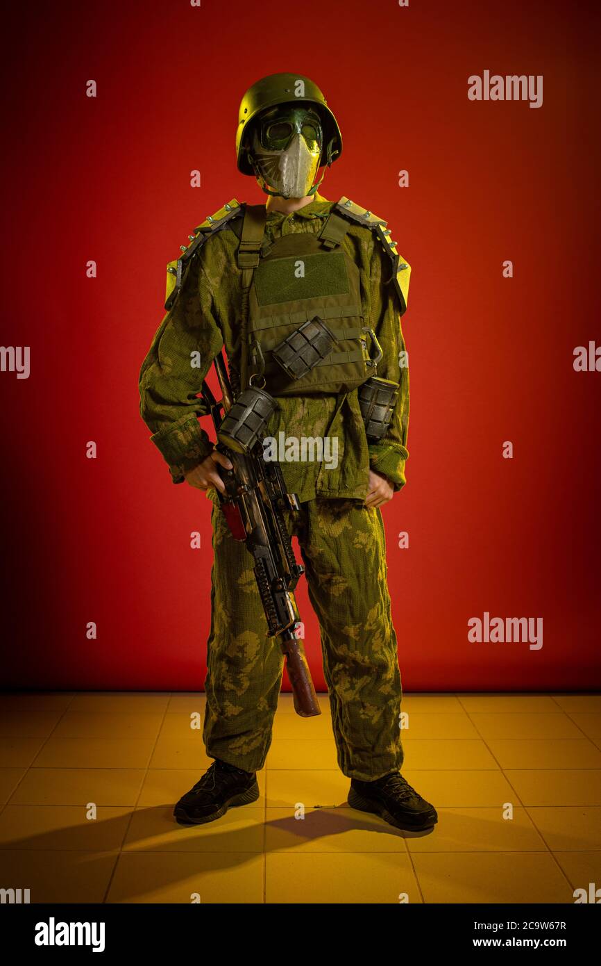 Actor man in a military helmet, mask and uniform posing on a red ...