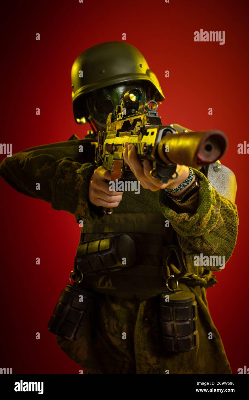 Actor man in a military helmet, mask and uniform posing on a red ...